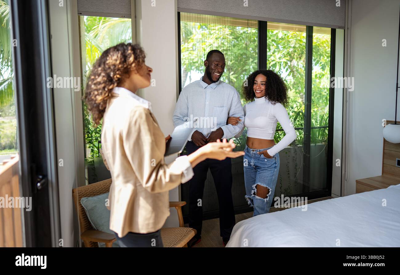 Real estate agent showing a diverse couple their new modern apartment ...