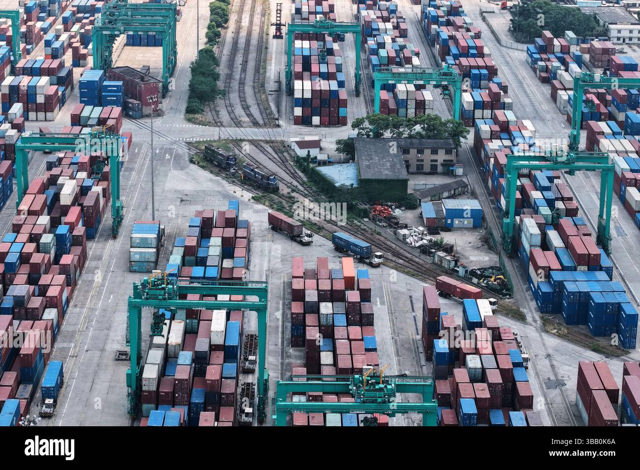 Trucks move past container pile-up at a container terminal, in Shanghai ...