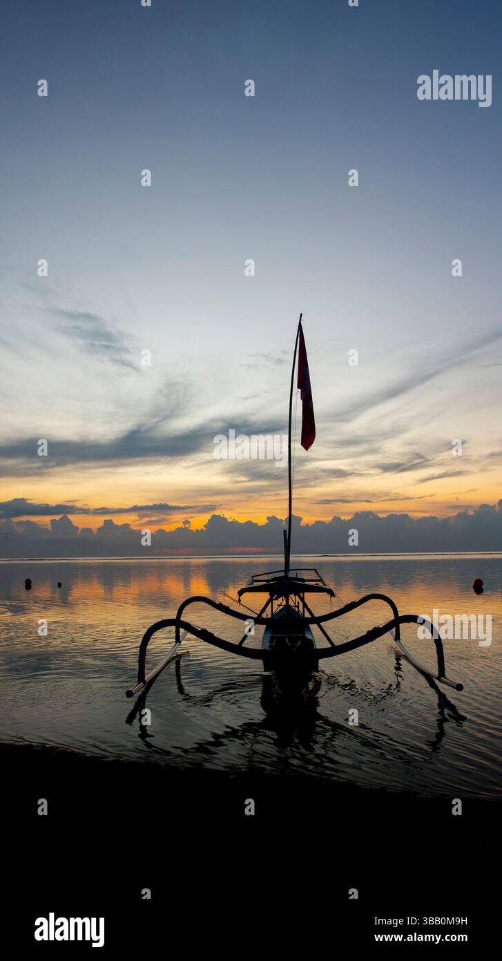 Traditional Balinese fishing boat, a Jukung, at Sanur, Bali, at sunrise ...