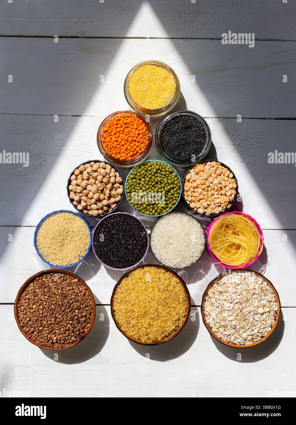 Assorted Grains and Legumes in Bowls Arranged in Pyramid Shape on White ...