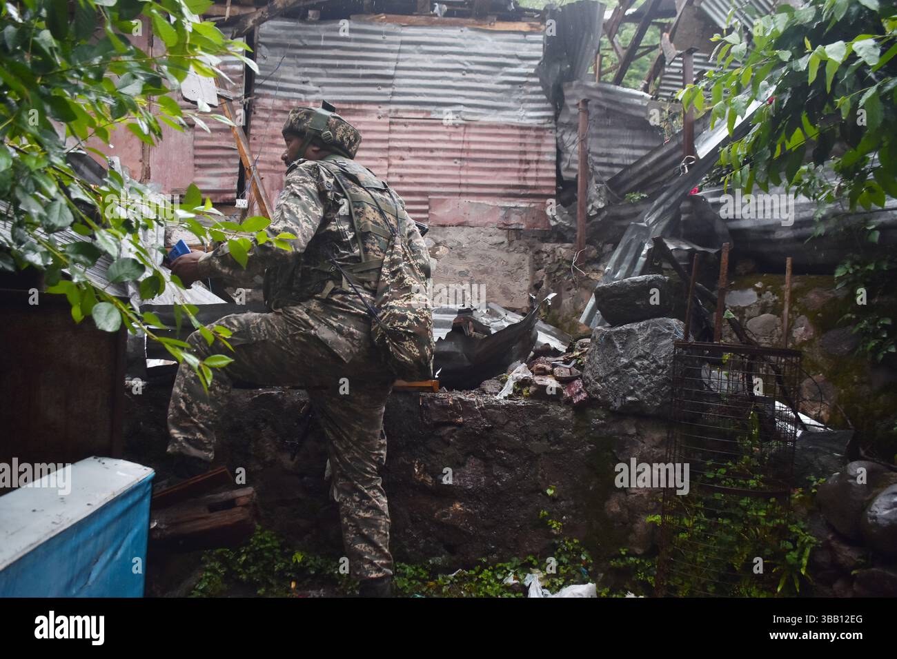 Indian paramilitary troopers assess a damaged shop in Uri town ...
