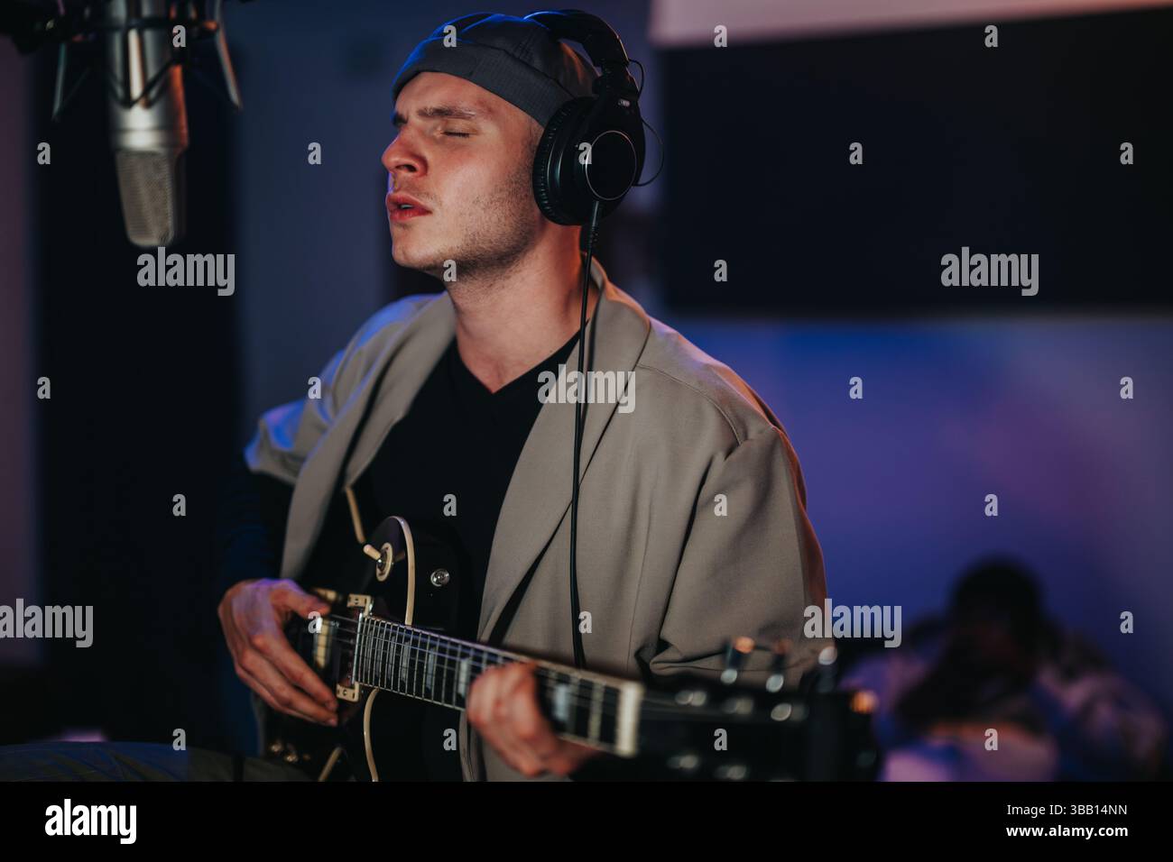 Musician passionately performing guitar in a professional recording ...
