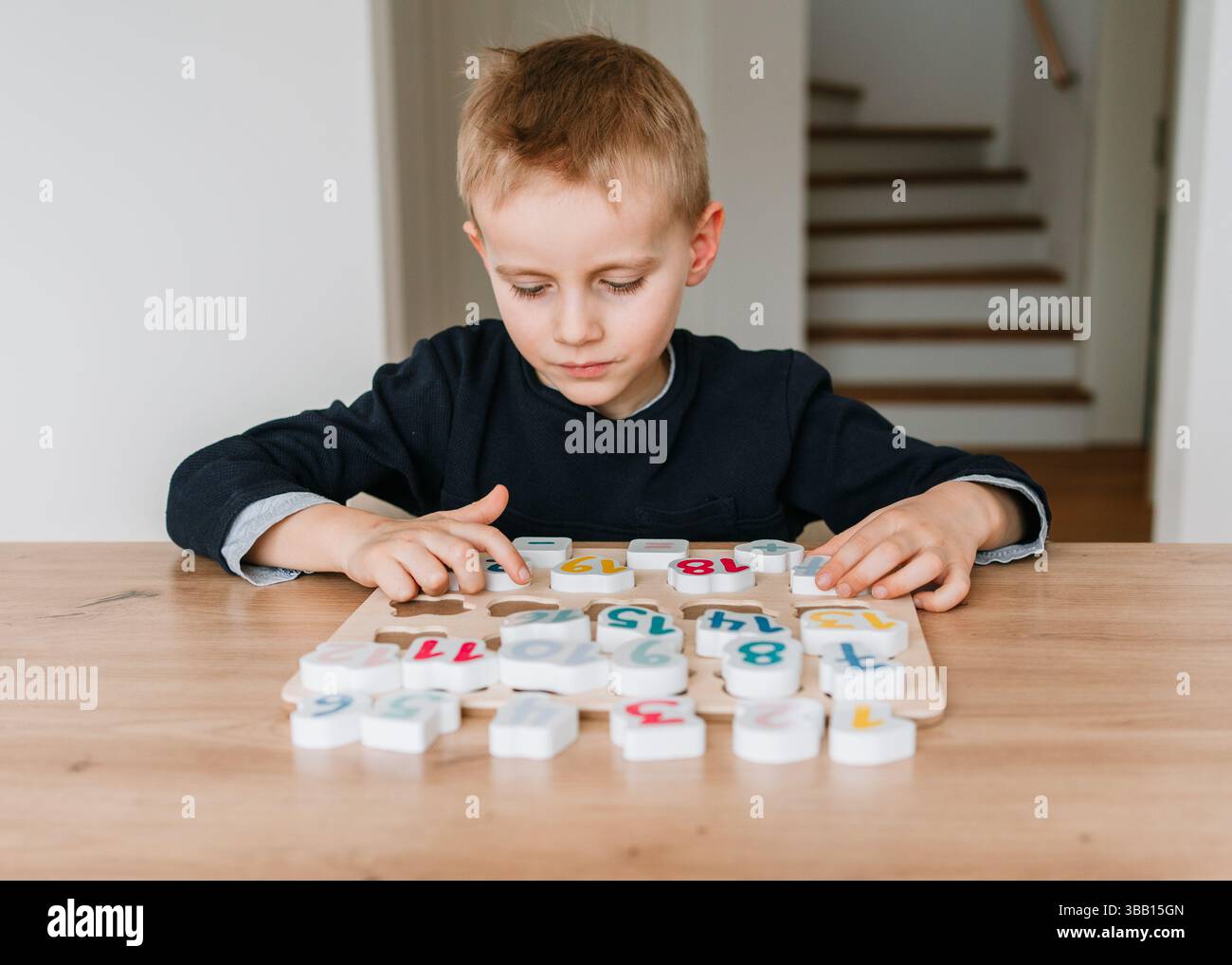 boy learns to count by laying out numbers from 1 to 20 on the board ...