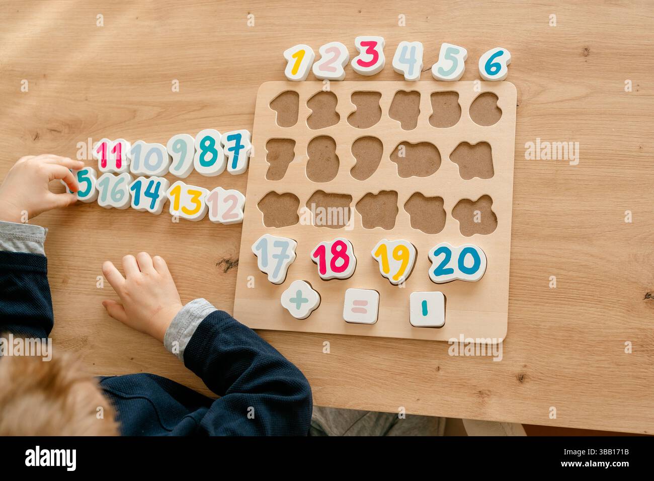 boy learns to count by laying out numbers from 1 to 20 on the board ...