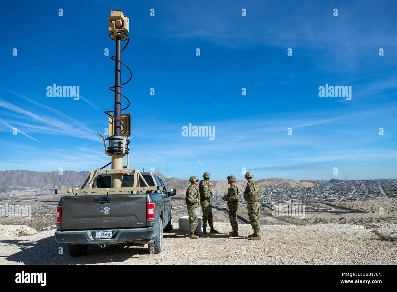 FILE - Army soldiers look at the border wall next to a surveillance ...