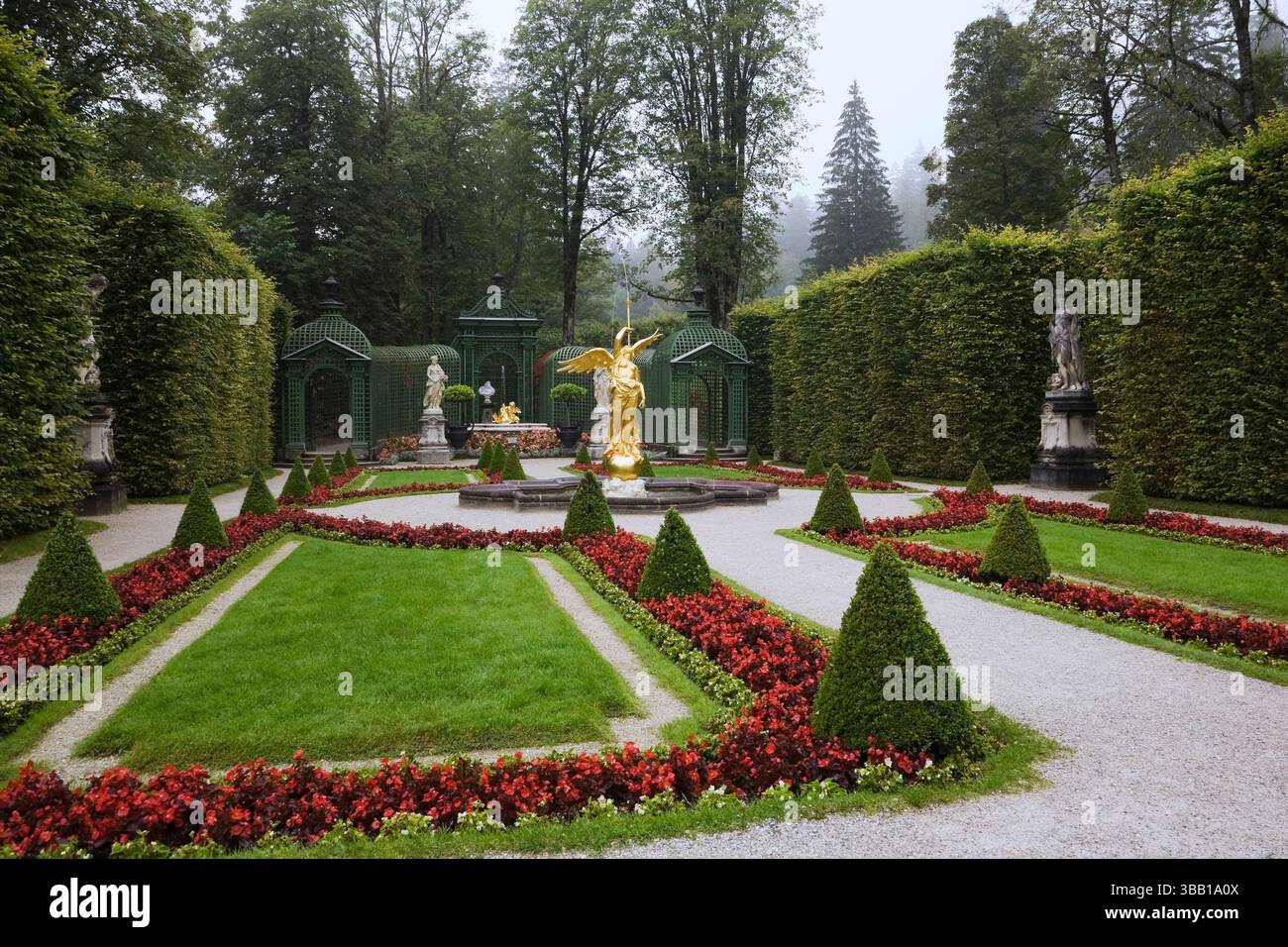 Parterre with red Begonias, topiary in borders and sculptures bordered ...