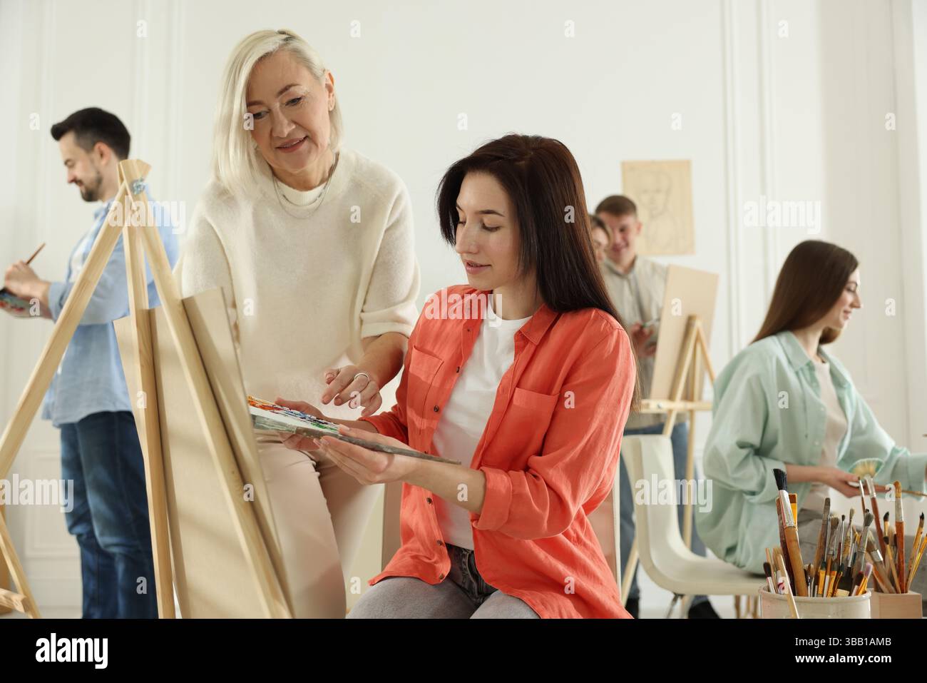 Artist and her students having painting class in studio Stock Photo - Alamy