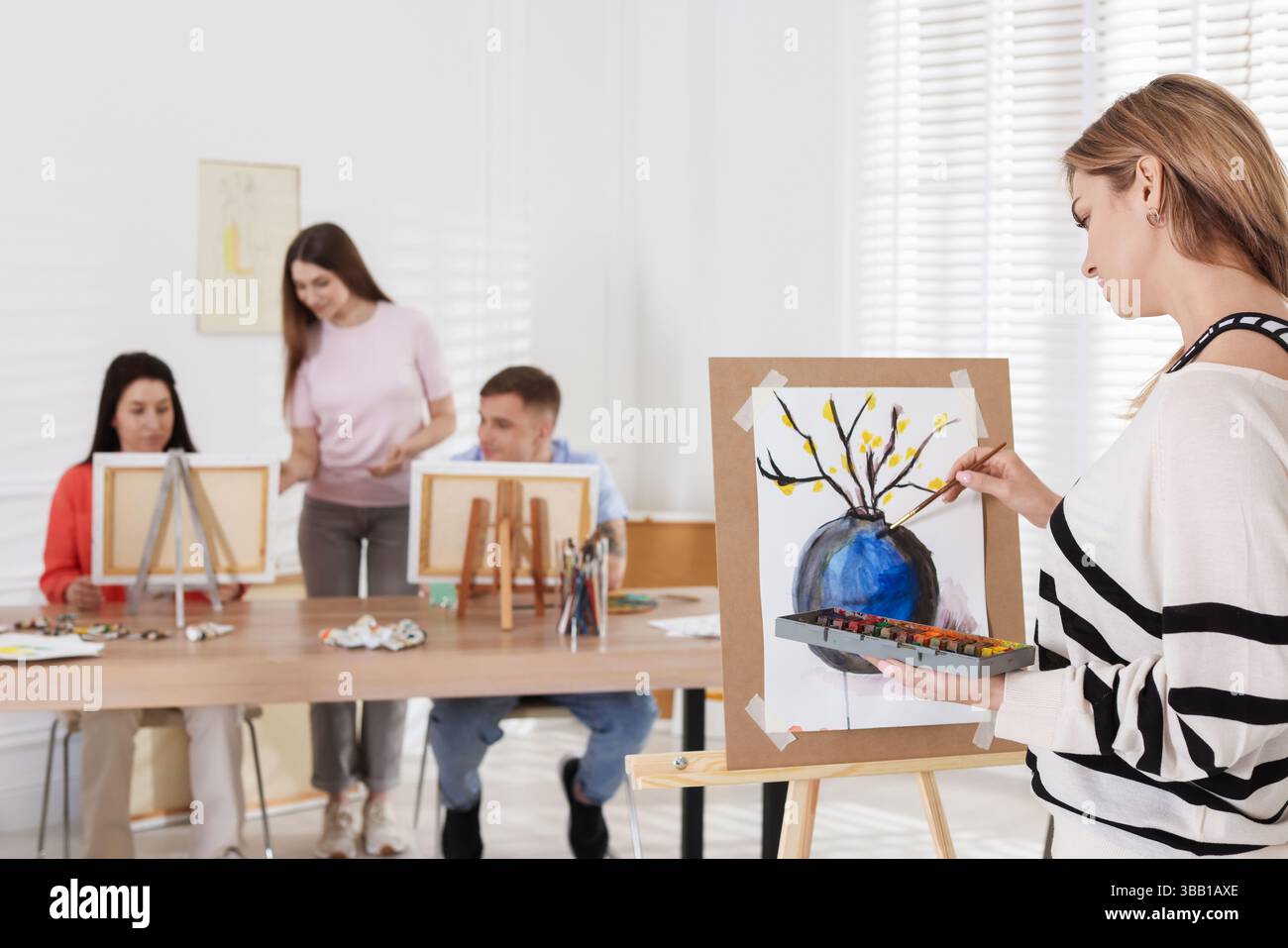Artist and her students having painting class in studio Stock Photo - Alamy