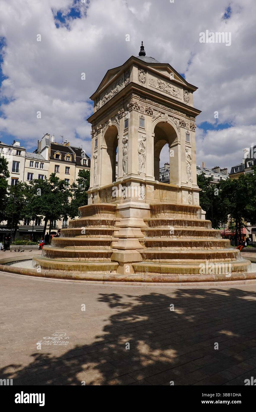 People sitting around the Fontaine des Innocents, a public fountain on ...