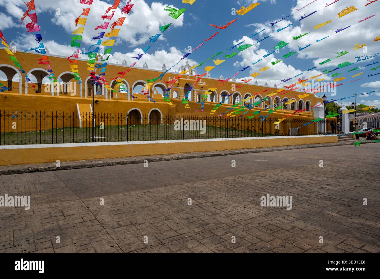 Colorful flags and the yellow Convento de San Antonio in Izamal ...