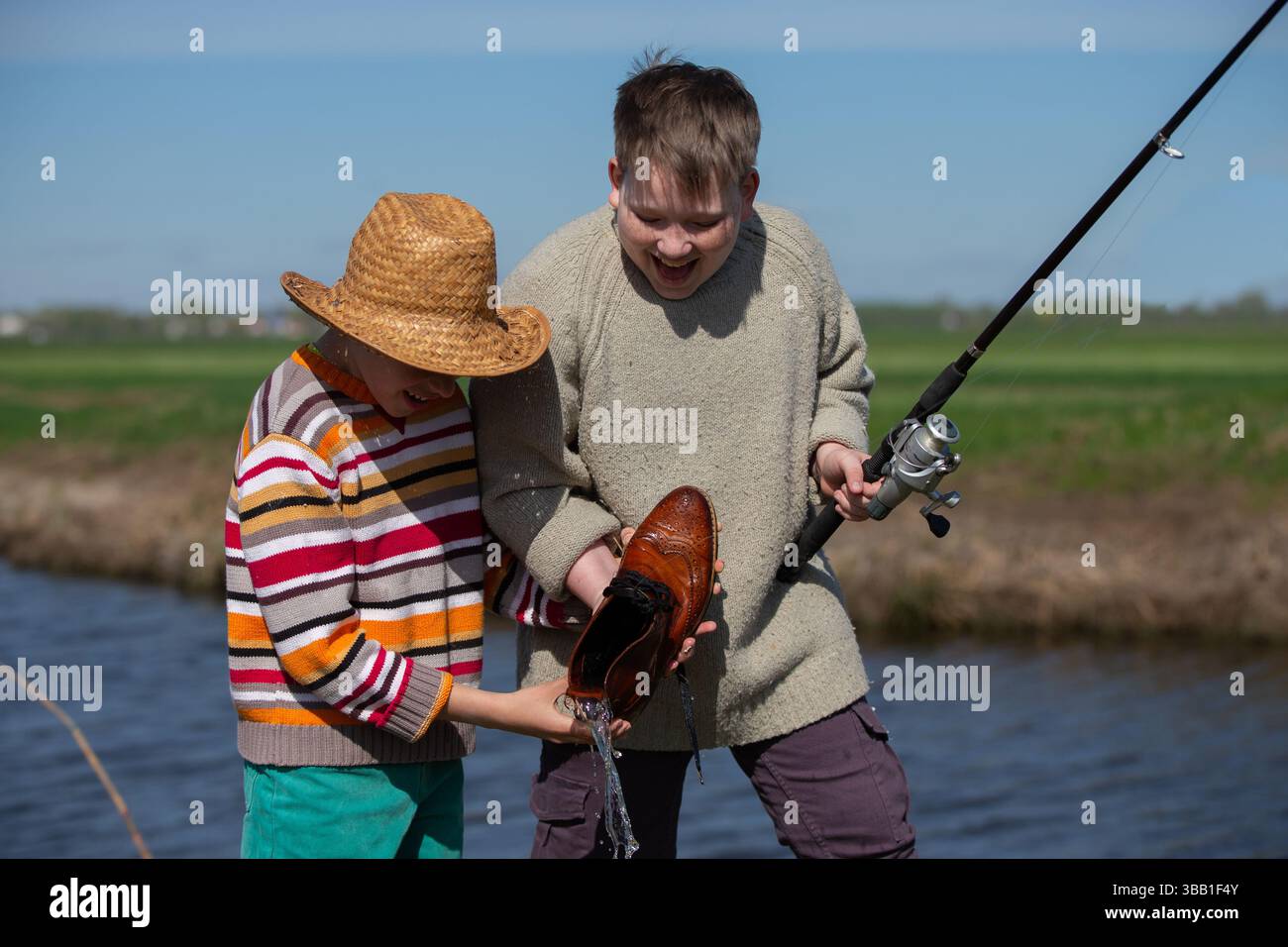 Funny fishing. Two of the boy's friends hooked an old shoe with a ...