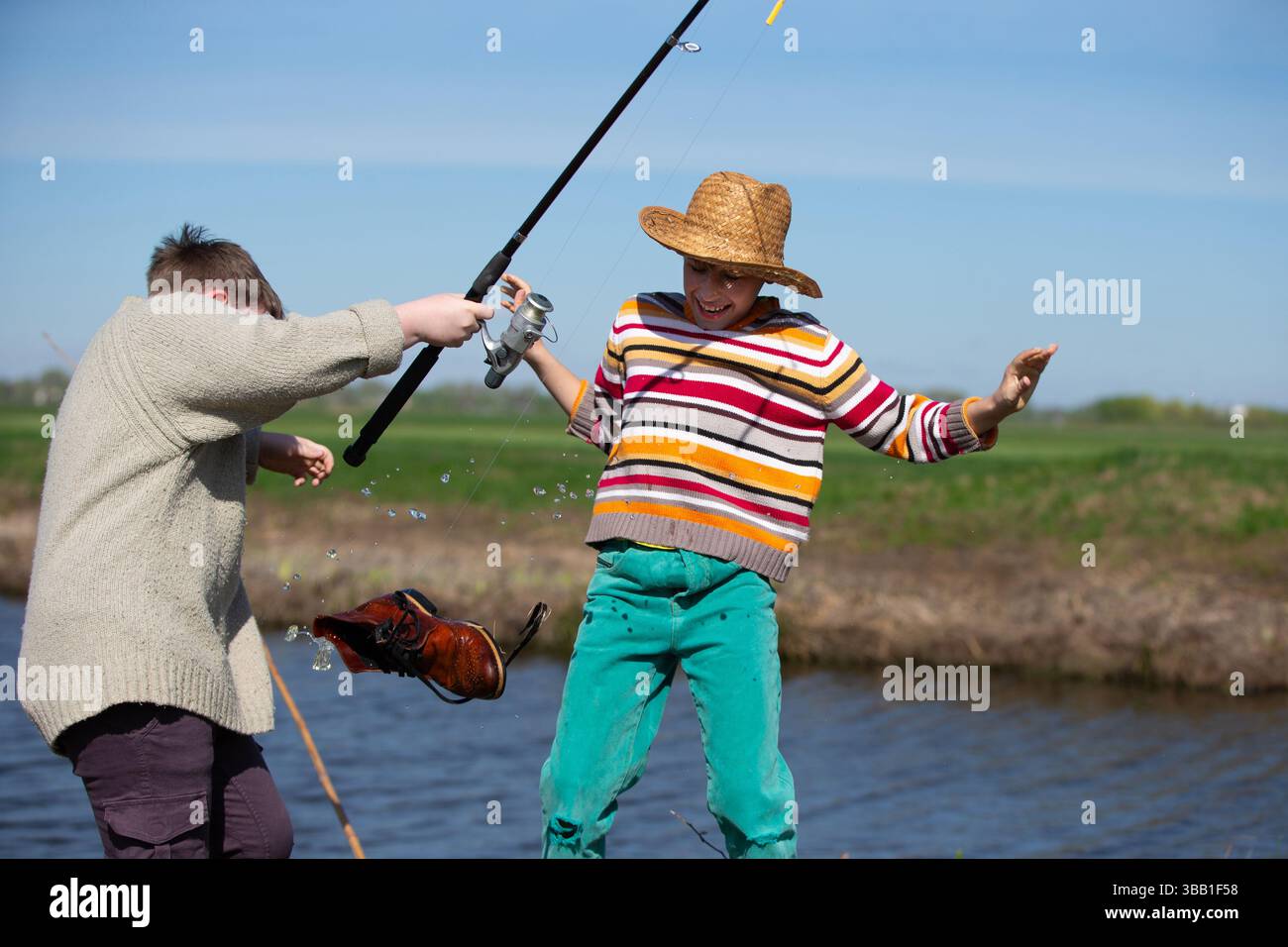 Funny fishing. Two of the boy's friends hooked an old shoe with a ...