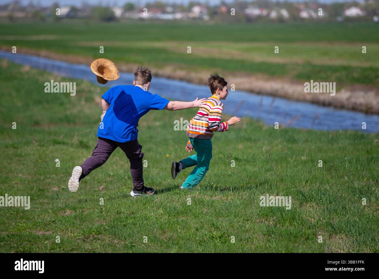 Two boys running after each other in nature. Children on summer ...