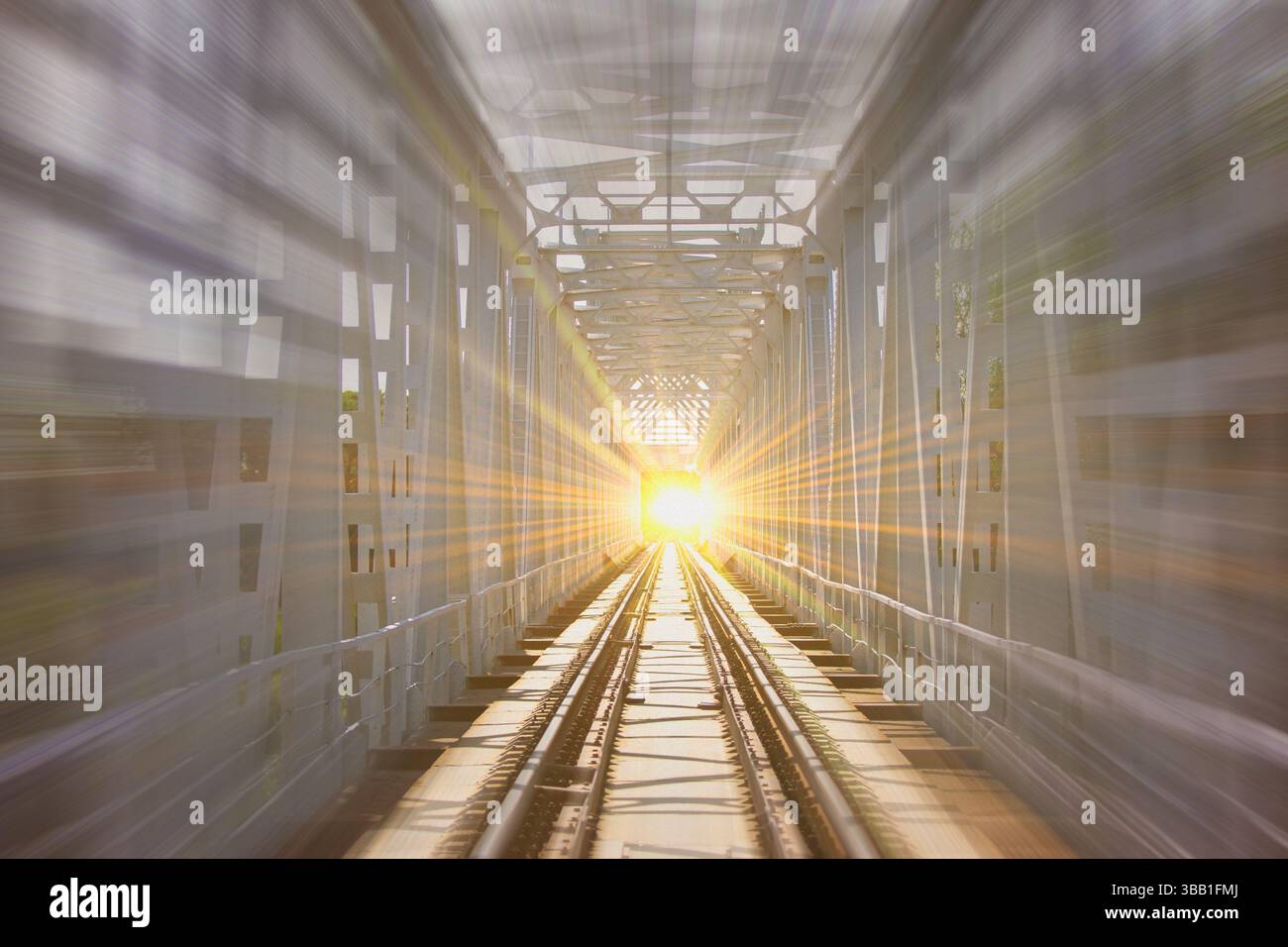 A railway tunnel with the sun shining through. The tunnel is long and ...