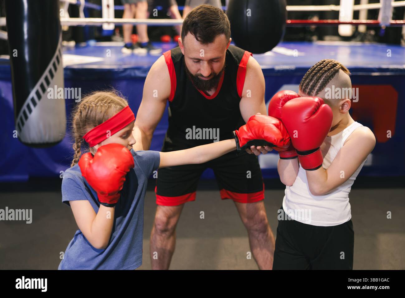 Boxing coach training children in sport center Stock Photo - Alamy