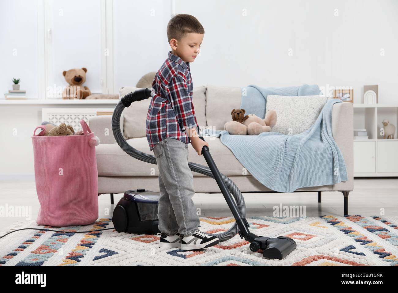 Little helper. Cute boy vacuuming at home Stock Photo - Alamy