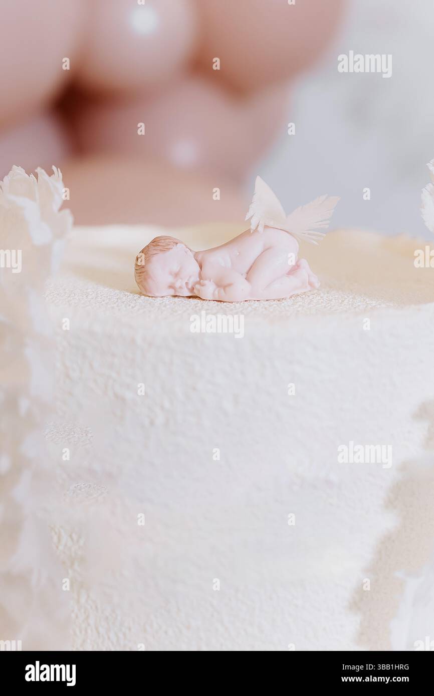 White cake for celebrating a child's baptism. Sweet cake with white wings. Photo zone for a ...