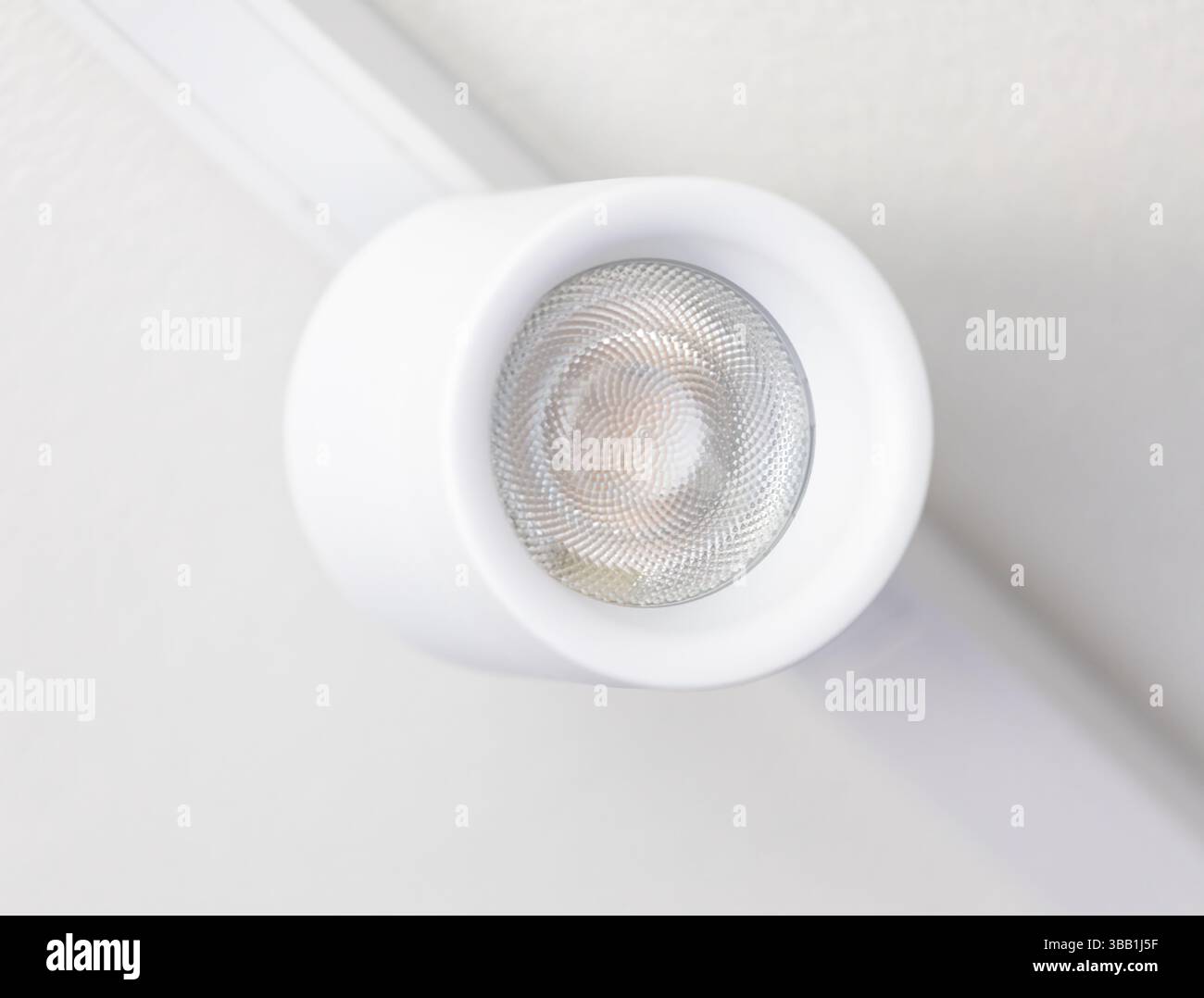 Close up of a modern white LED spotlight attached to a white track ...