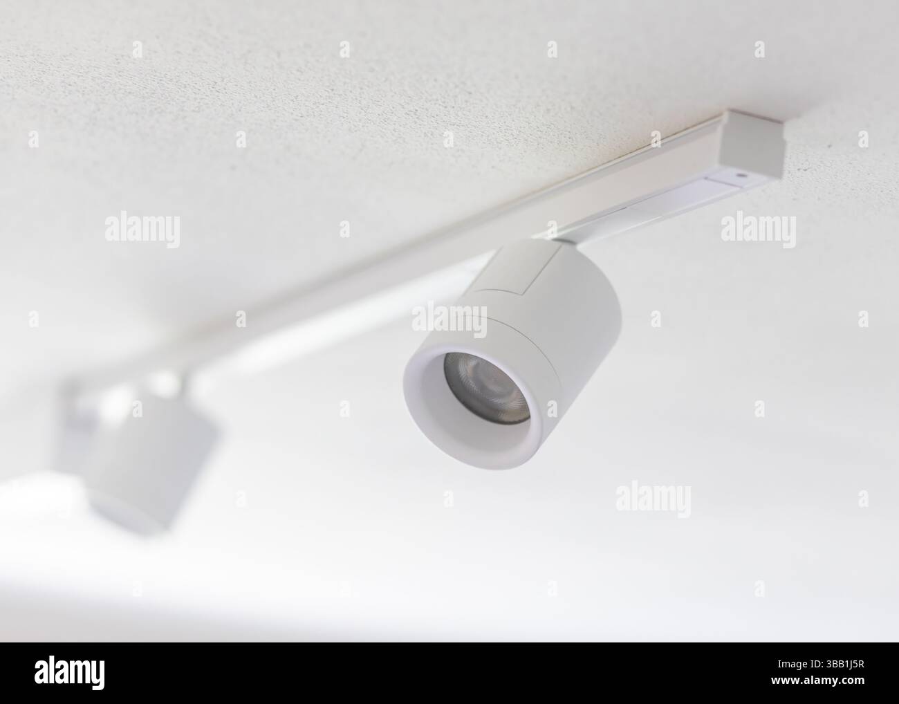 Hanging from a ceiling track lighting system hi-res stock photography ...