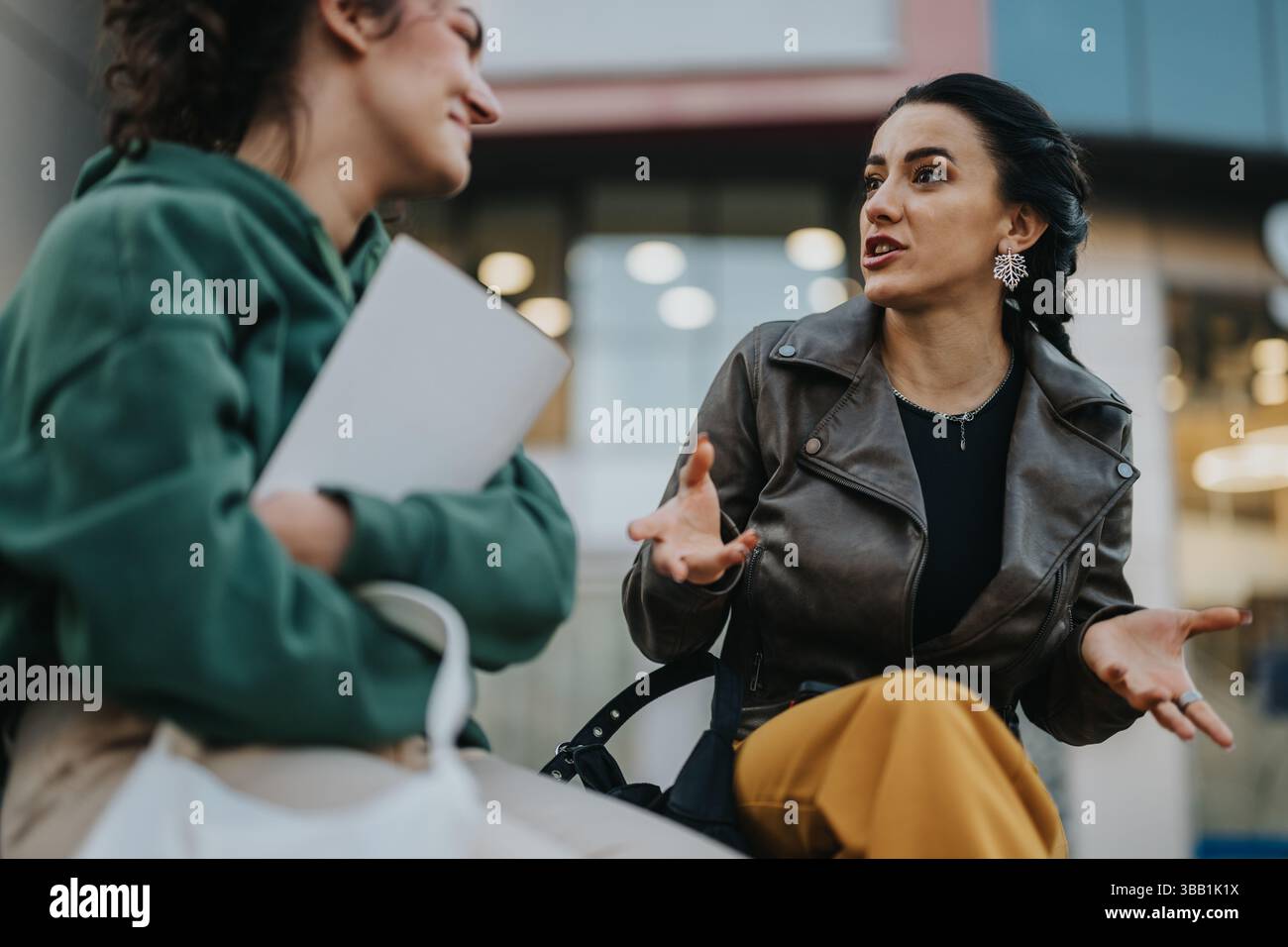 Two women having an animated conversation outdoors with expressive ...