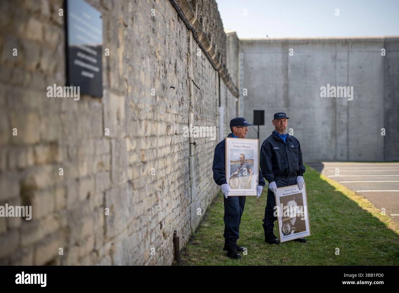 French prison officers, hold portraits of the two victims during a ...