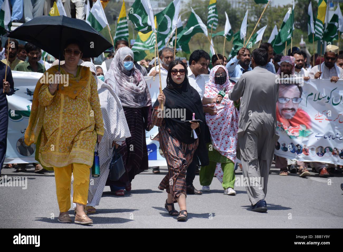 Islamabad, Pakistan. 14th May, 2025. People hold flags as they march ...