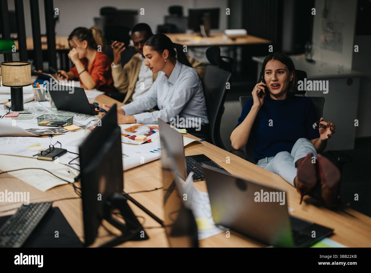 Business colleagues engaged in a late-night brainstorming session ...