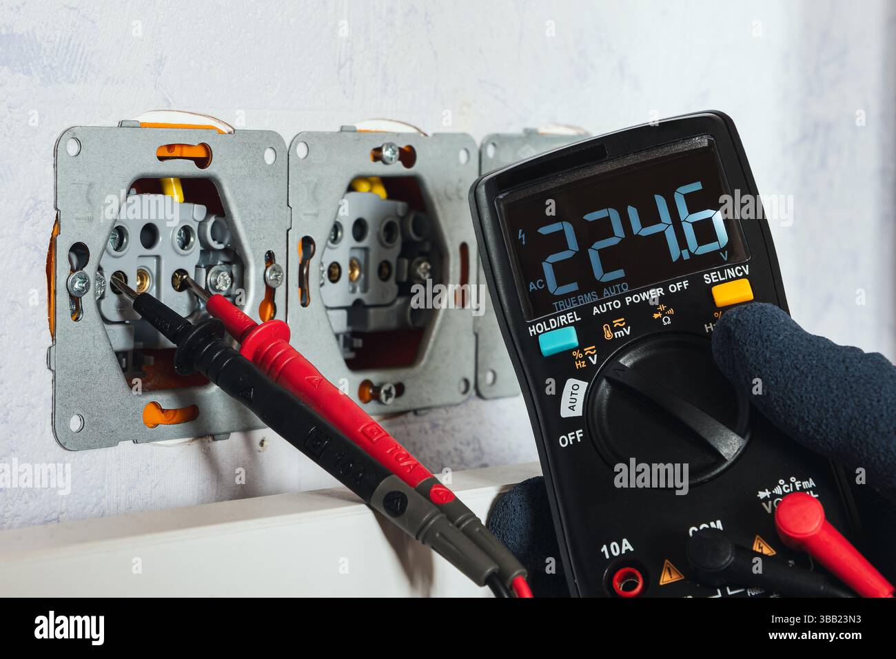 Multimeter (voltmeter) measuring voltage in a wall socket — practical demonstration of ...
