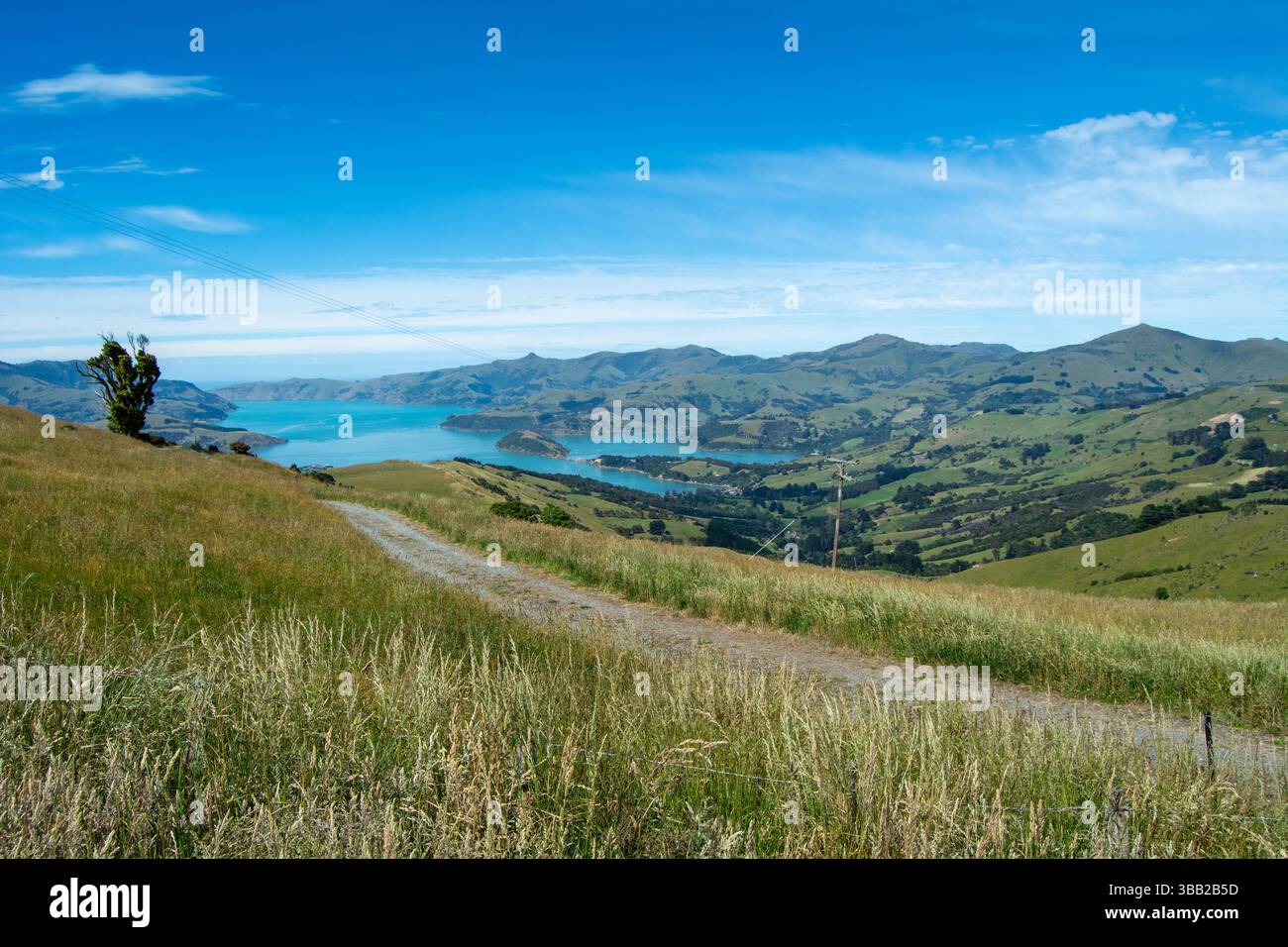 A scenic view of rolling hills and a tranquil bay under a clear blue ...