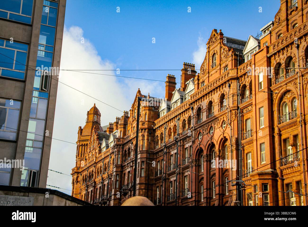 Red-brick Edwardian buildings lined along a bustling street on a bright ...