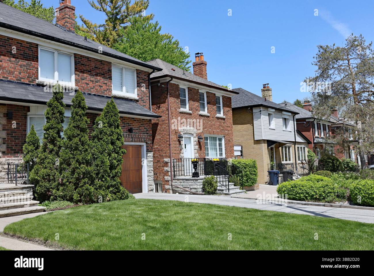 Suburban street with row of traditional detached two story houses Stock ...