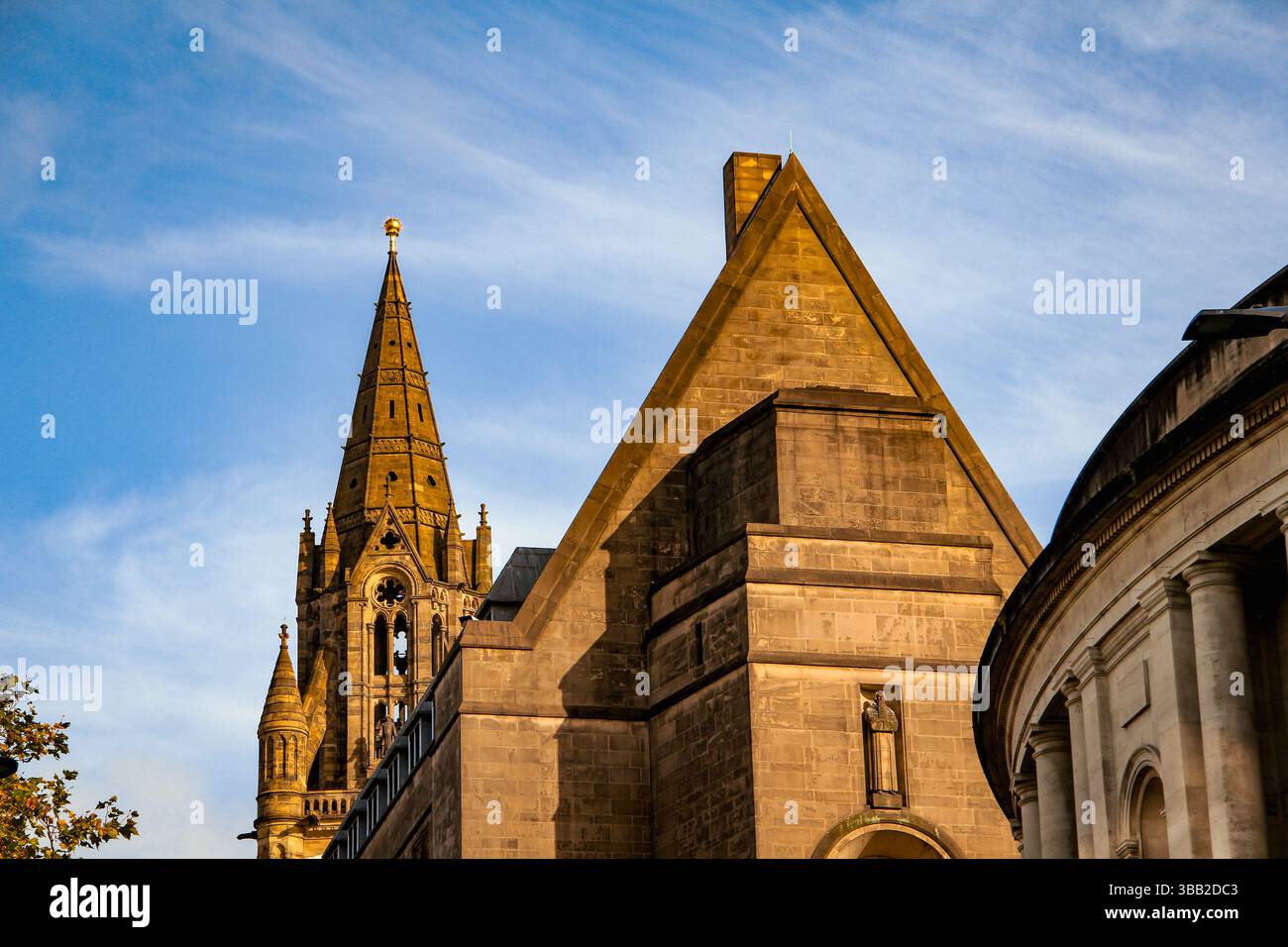 Twin gothic spires and arched windows of a historic church under blue ...