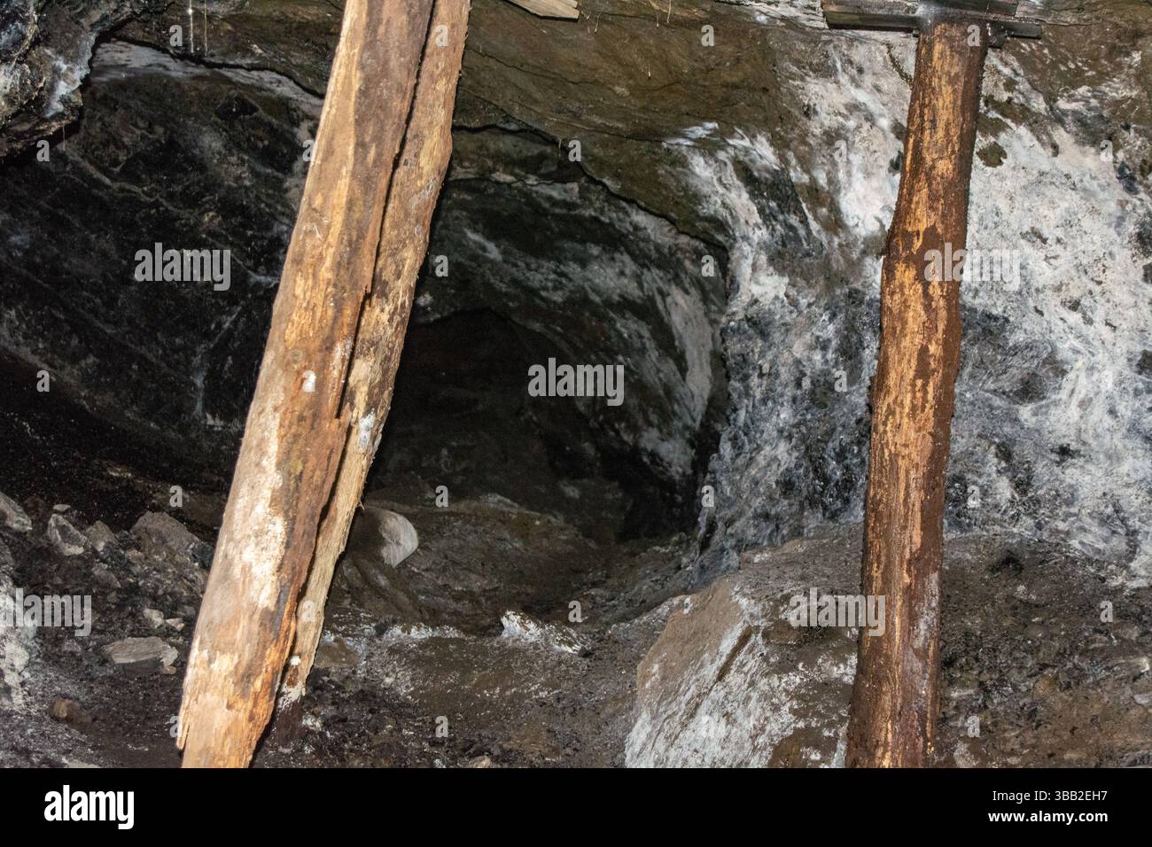 An underground mine shaft with wooden supports, showing rocky walls and ...
