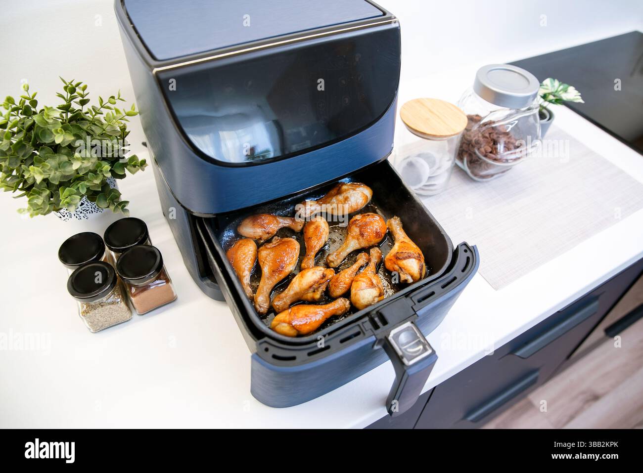 Air fryer machine in the kitchen. Baked chicken legs Stock Photo - Alamy