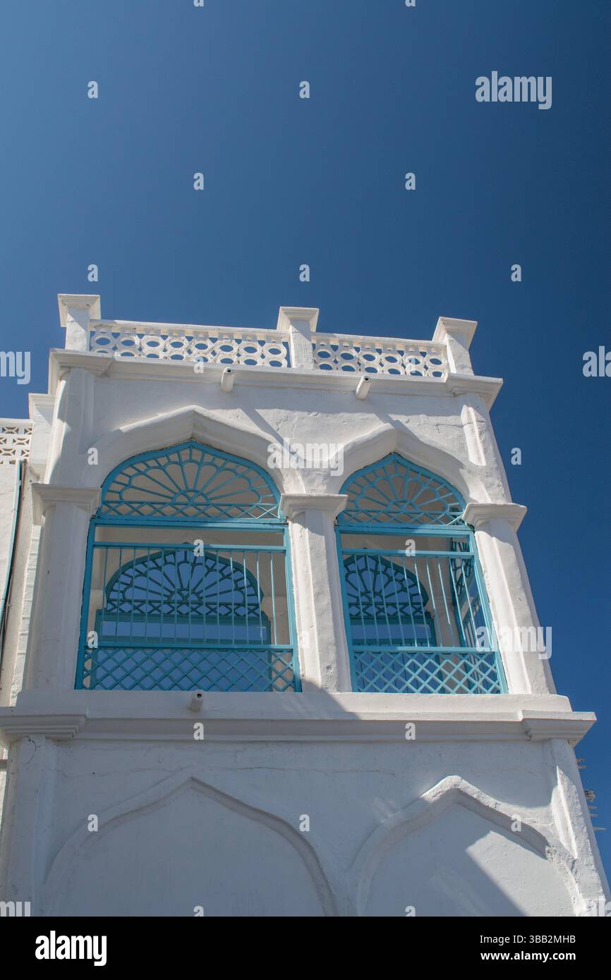 Oman: white house with blue windows on Mutrah Corniche, typical skyline ...