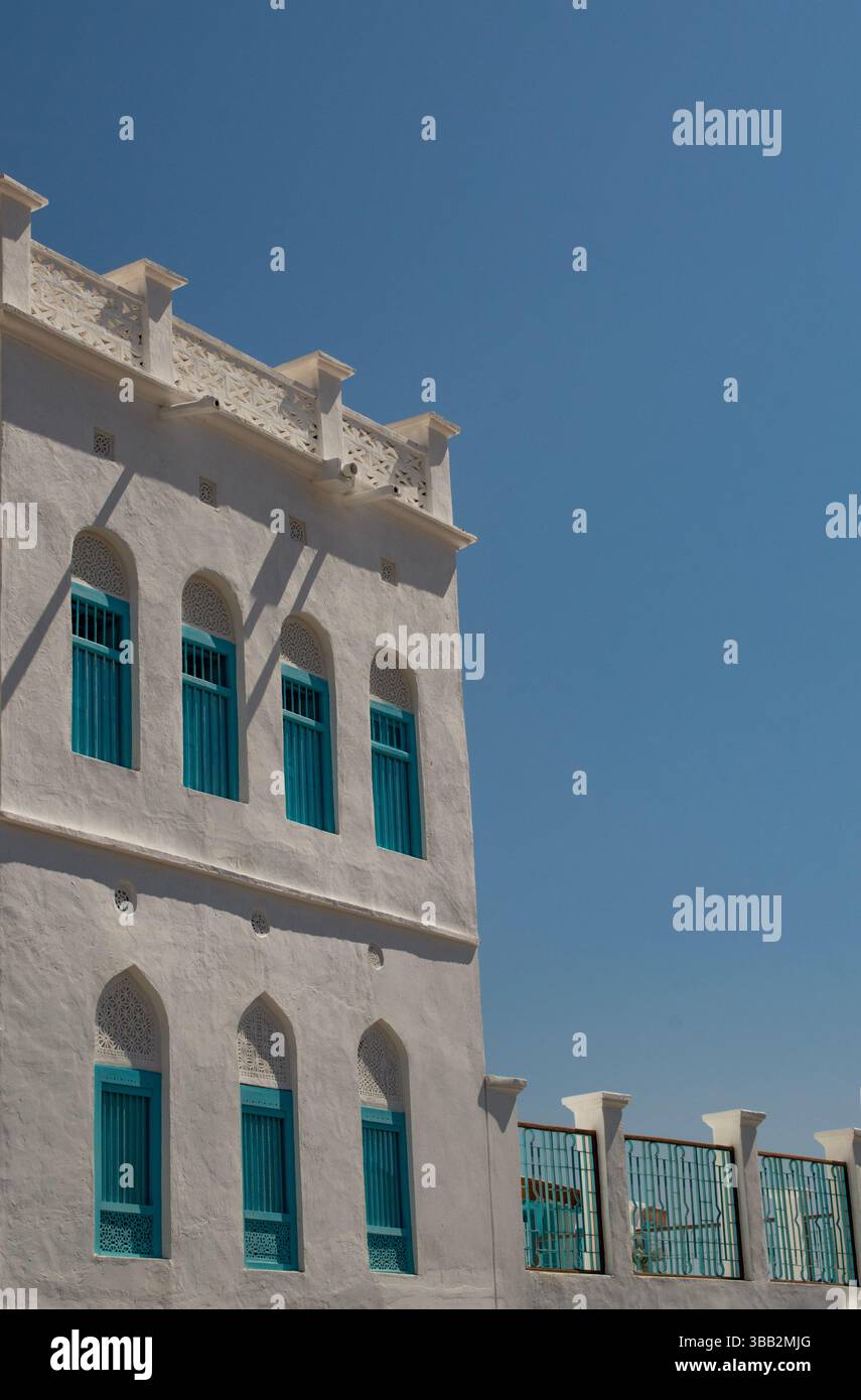 Oman: white house with blue windows on Mutrah Corniche, typical skyline ...