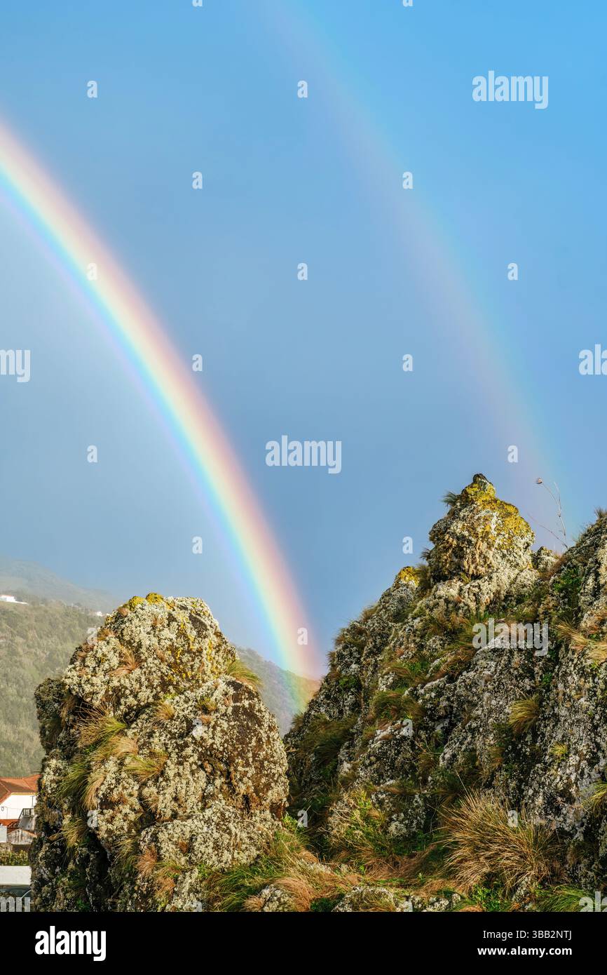 Double Rainbow Arches Over Rocky Landscape. Vibrant primary and ...