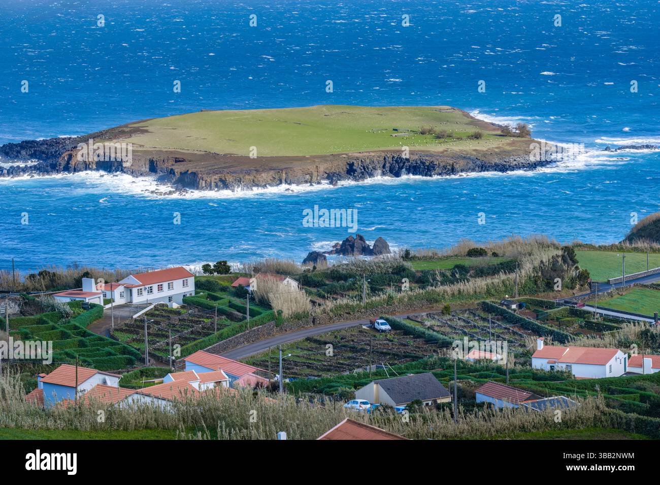 Topo Islet and Ponta do Topo, Sao Jorge, Azores. Green islet surrounded ...