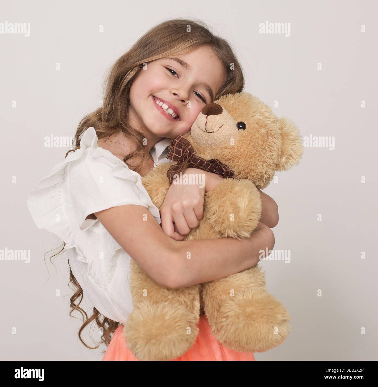 Adorable little girl hugging teddy bear Stock Photo - Alamy