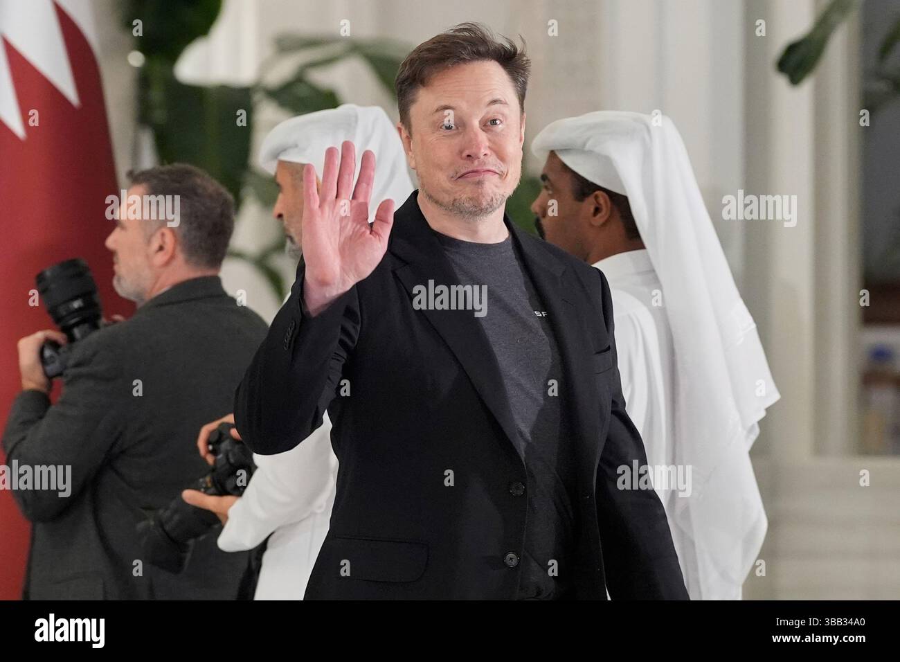 Elon Musk gestures as he arrives for a state dinner hosted by Qatar's ...