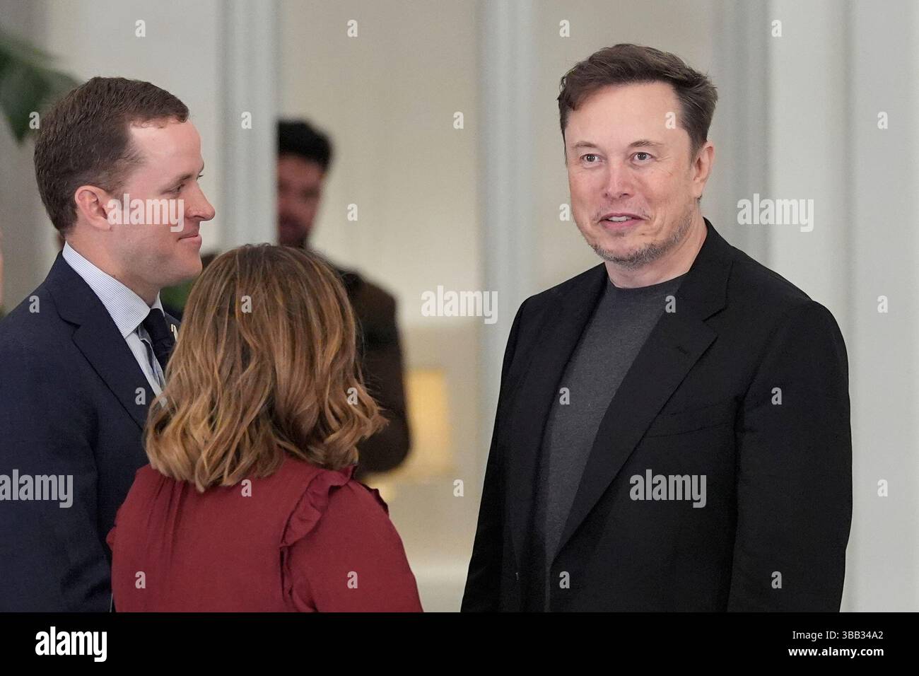 Elon Musk gestures as he arrives for a state dinner hosted by Qatar's ...