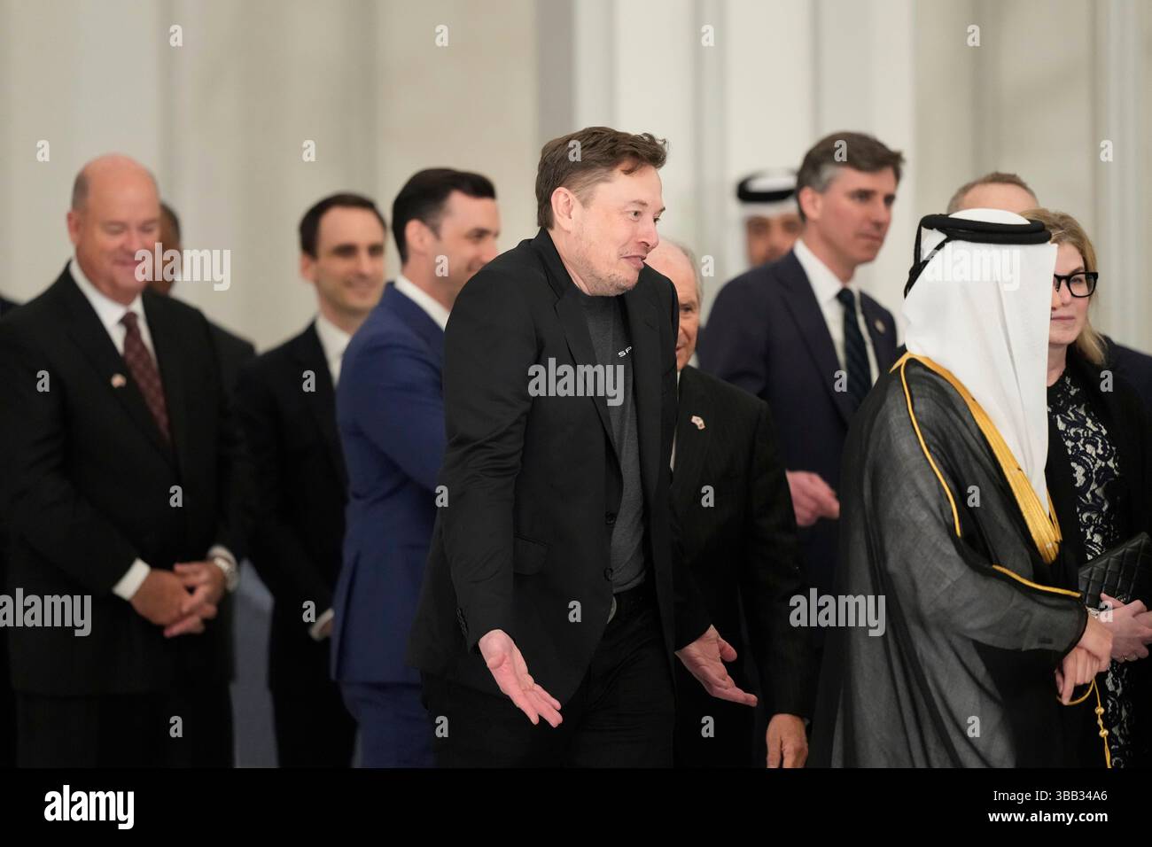 Elon Musk gestures as he arrives for a state dinner hosted by Qatar's ...