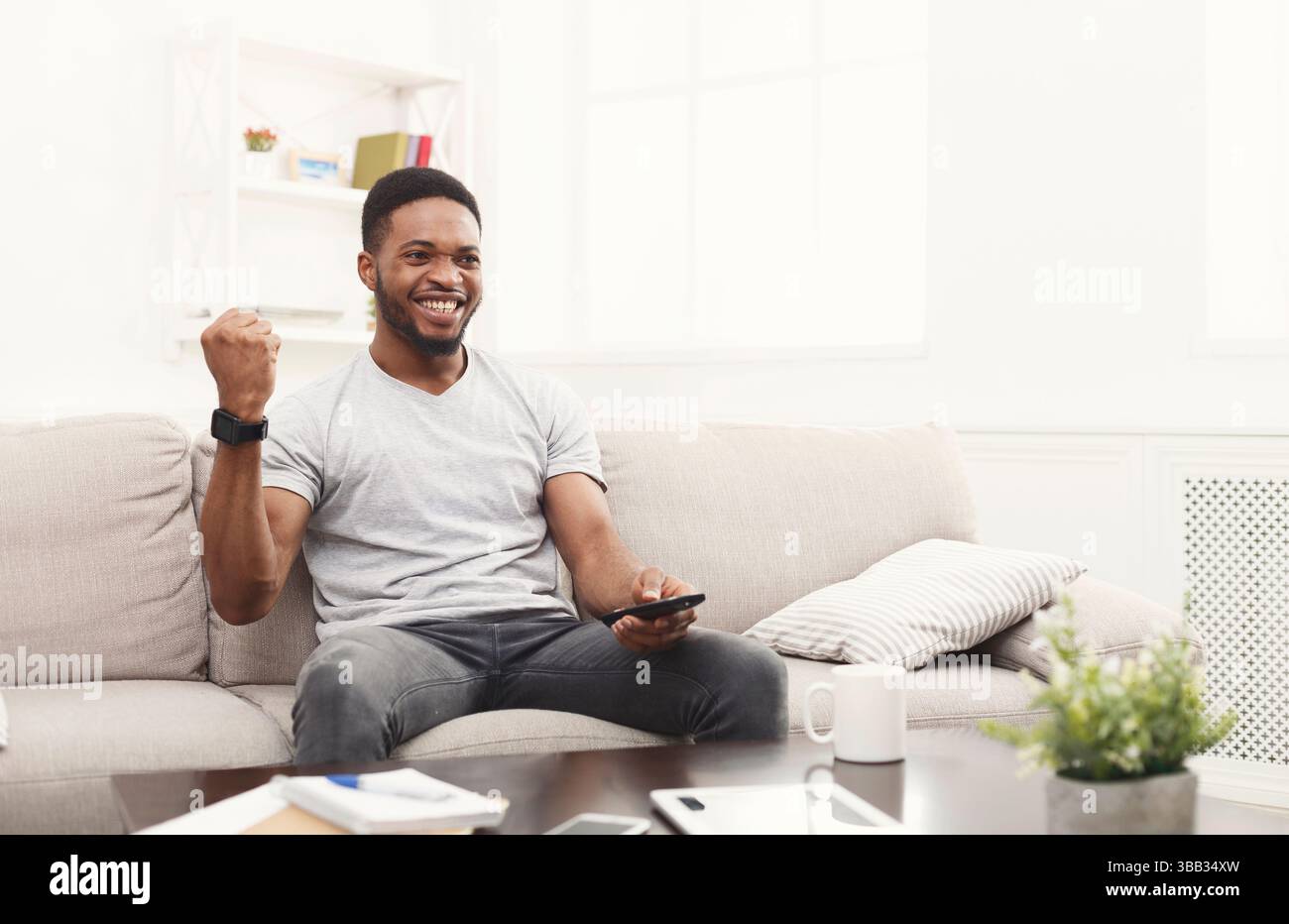Happy man watching tv using remote controller in living room Stock ...