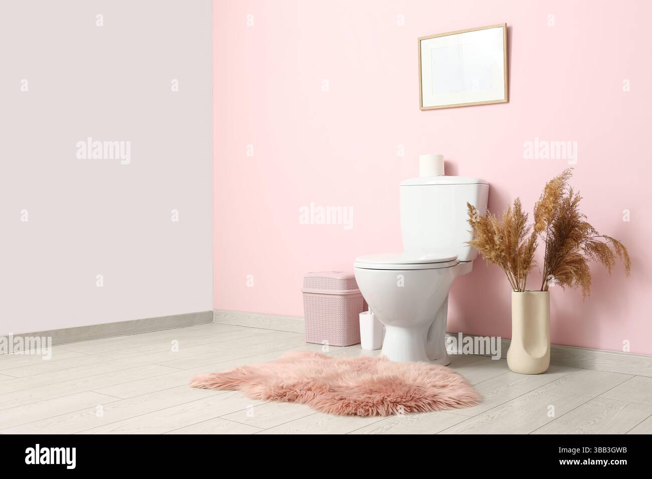 Interior of stylish restroom with ceramic toilet bowl, trash bin and ...