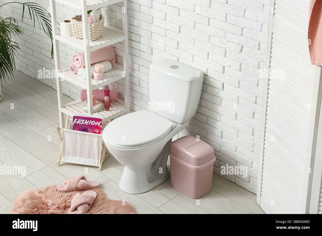 Interior of stylish restroom with ceramic toilet bowl, shelving unit ...