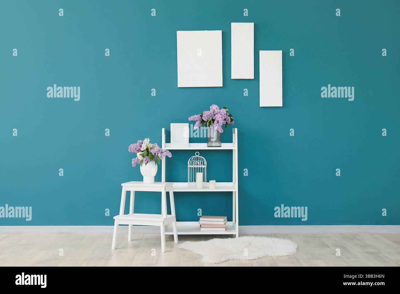 Interior of room with shelf unit, stool and lilac flowers in vases ...
