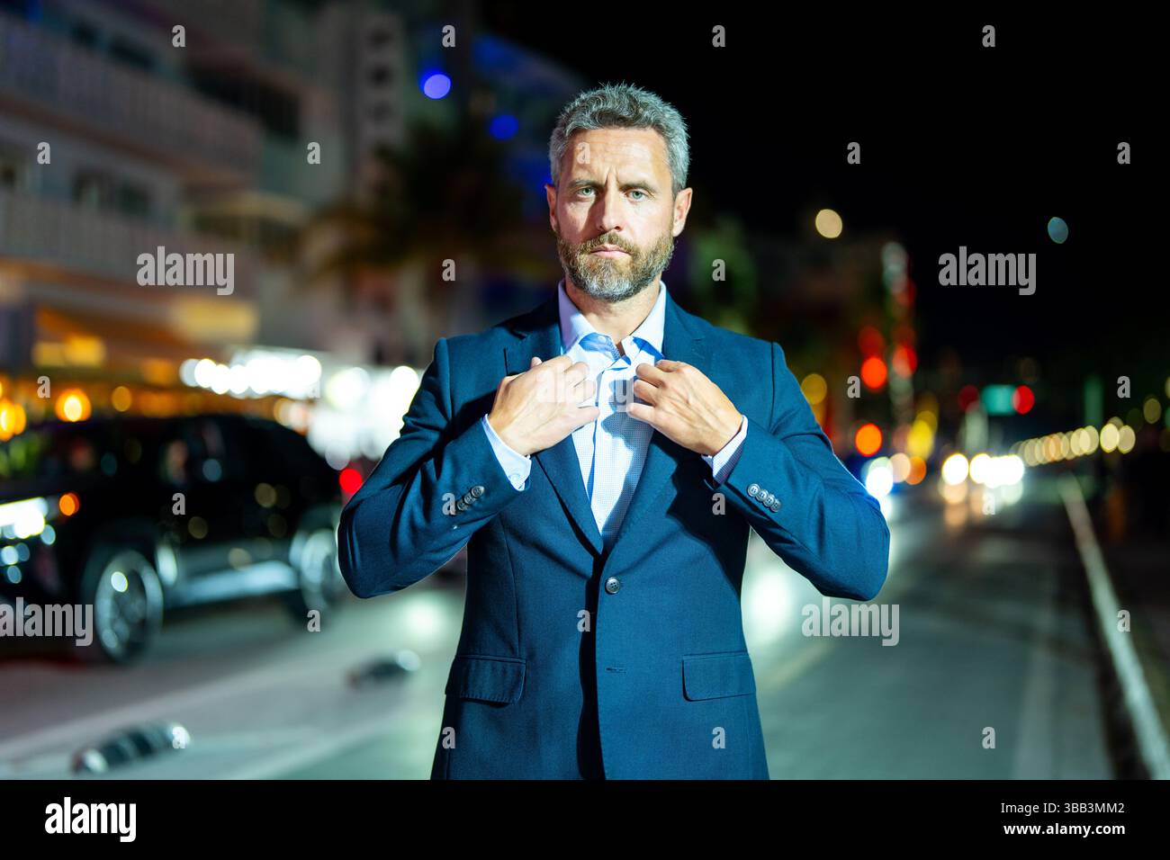 Successful businessman posing at night city. Rich man in a suit ...