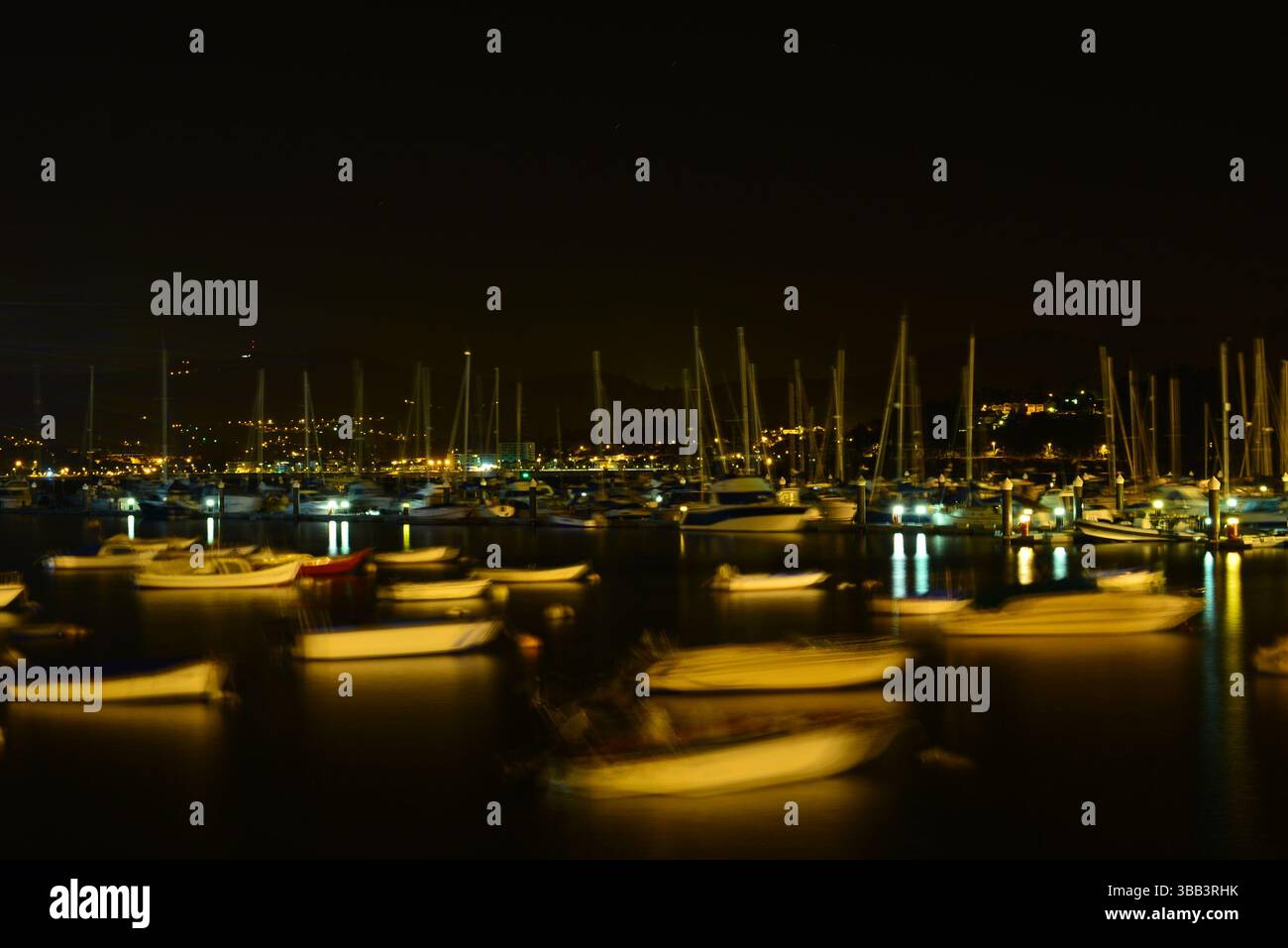 Reflections of light from the sailing boats anchored in the port of ...