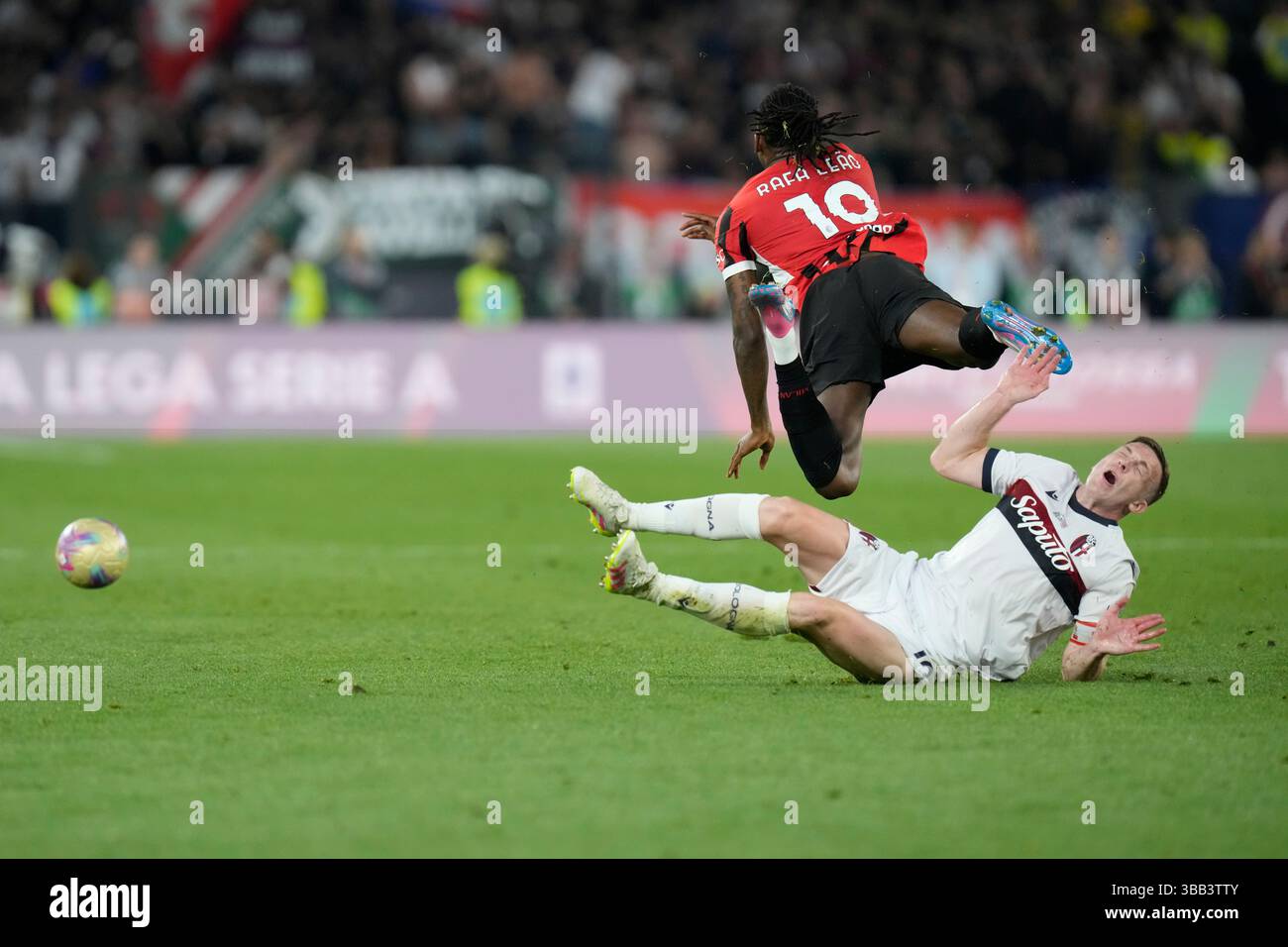 AC Milan's Rafael Leao, top, and Bologna's Lewis Ferguson challenge for ...