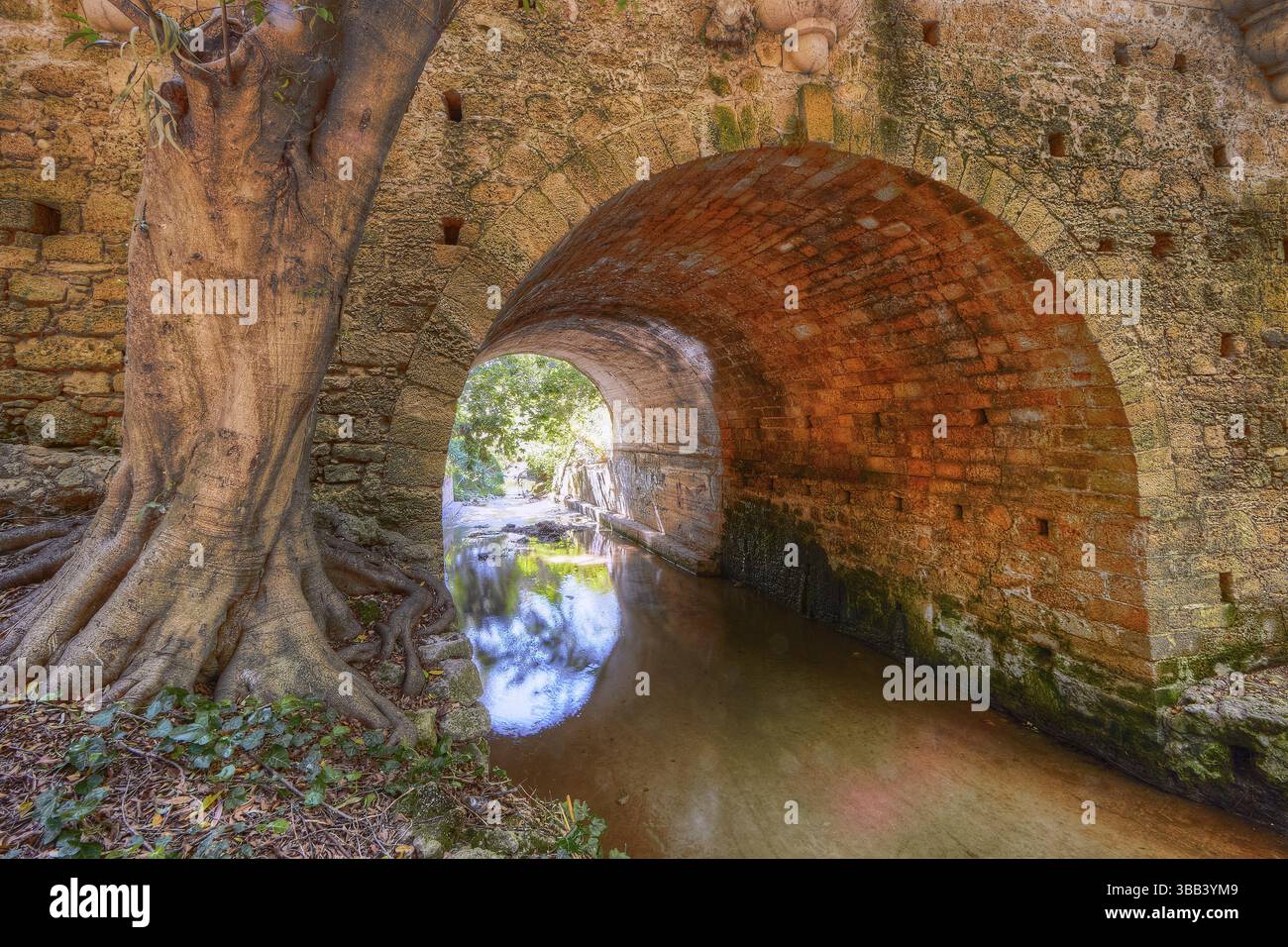Stone tunnel with tree and quiet river, pure nature, Rodini Park ...